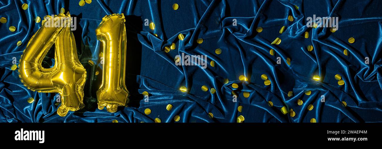 number forty one, gold foil balloon number on a blue velvet background ...