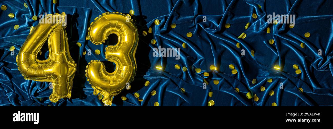 number forty three, gold foil balloon number on a blue velvet ...