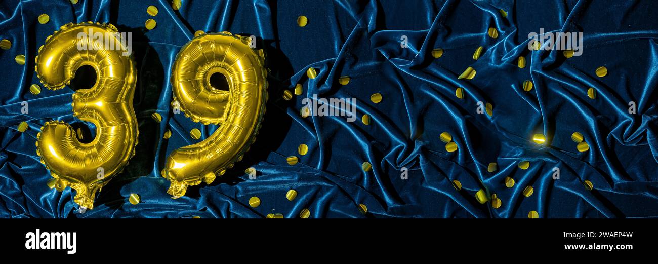 number thirty nine, gold foil balloon number on blue velvet background with confetti. Birthday ...