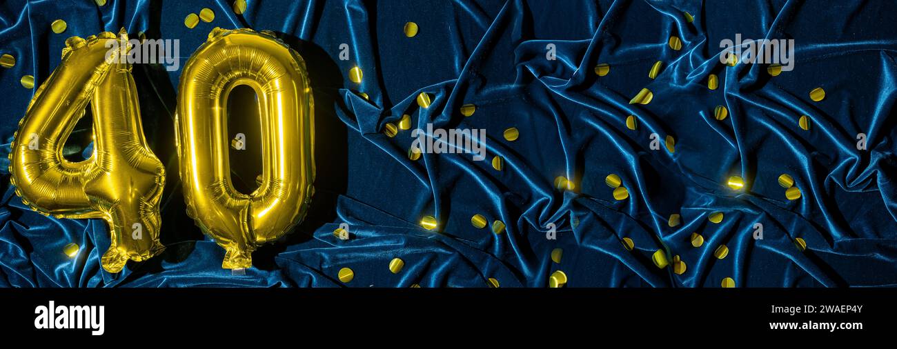 number forty, gold foil balloon number on a blue velvet background with ...