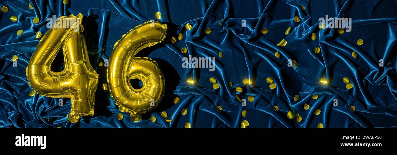 number forty six, gold foil balloon number on a blue velvet background ...