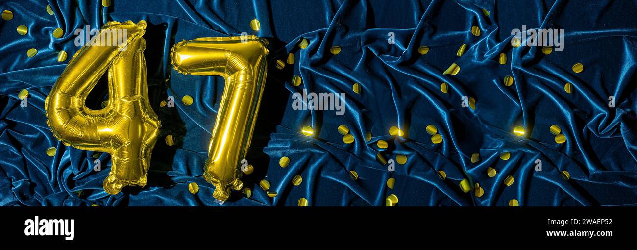 number forty seven, gold foil balloon number on a blue velvet ...