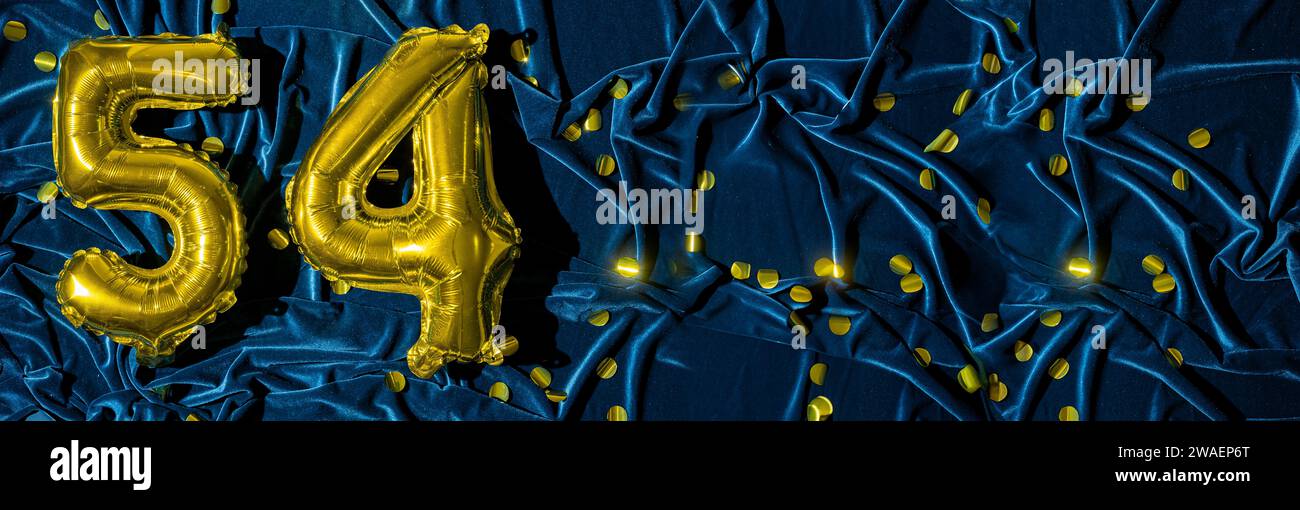 Gold foil balloon number number 54 on a background of blue velvet ...