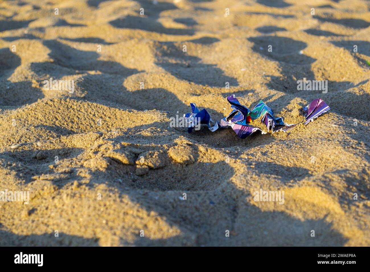 Paper trash sprinkled with sand on the sea beach Stock Photo - Alamy