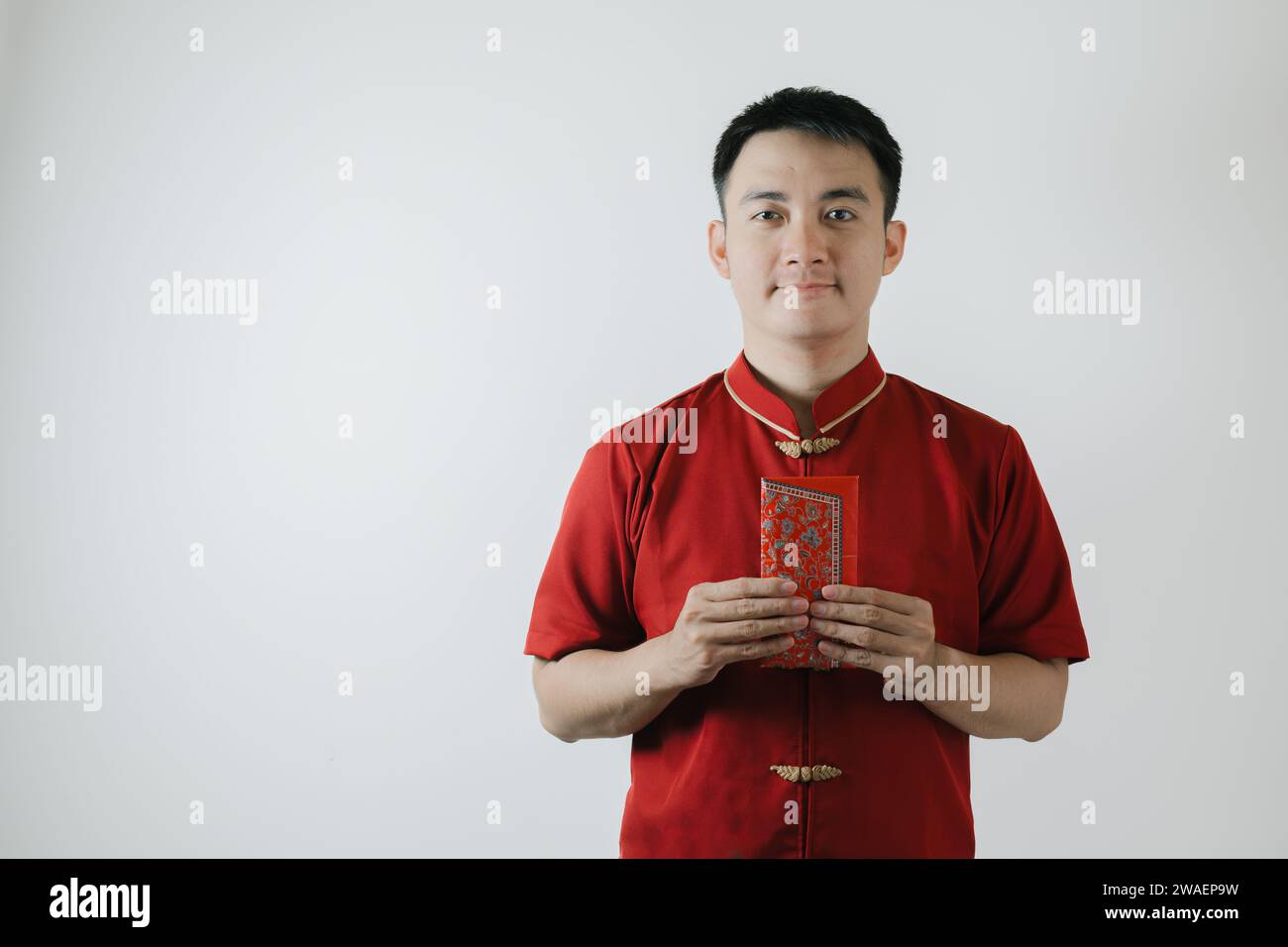 Asian man wearing Chinese traditional cloth called Cheongsam holding an ...