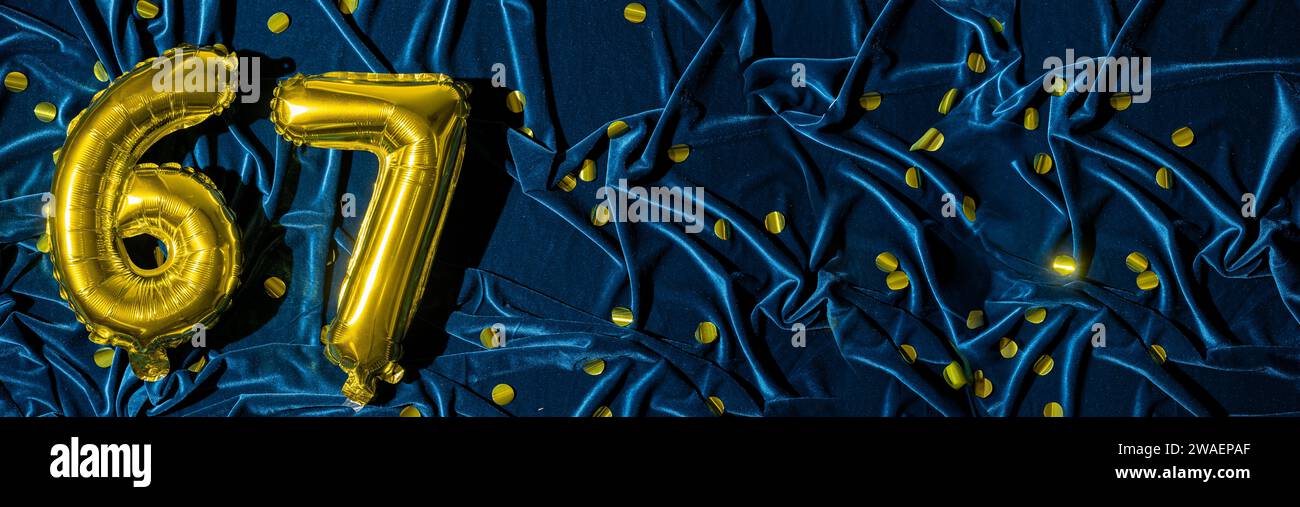 Gold foil balloon number number 67 on a background of blue velvet ...