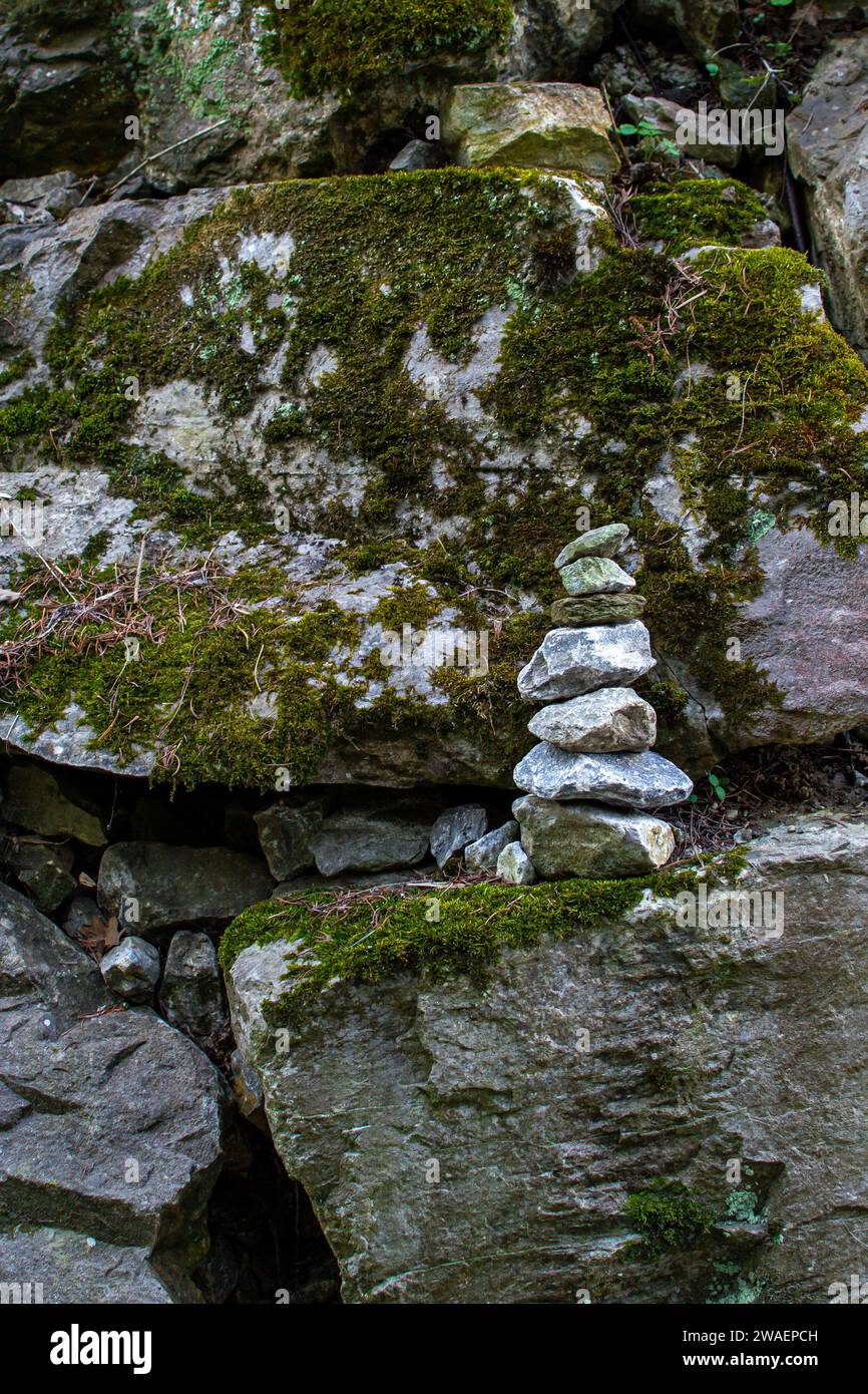 A small stone pyramid against the background of a stone covered with ...