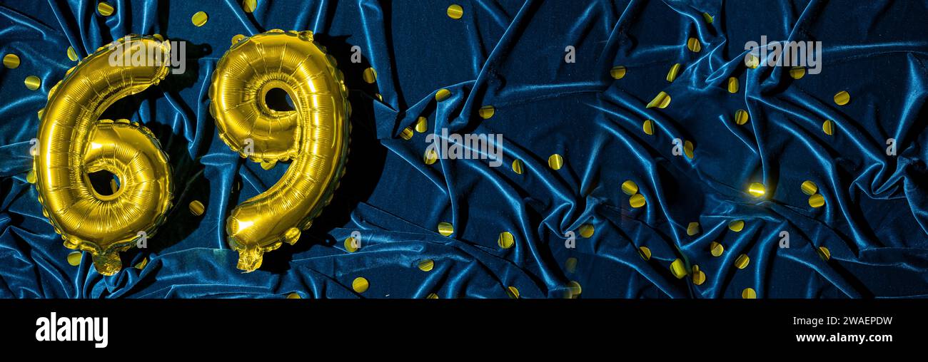 Gold foil balloon number number 69 on a background of blue velvet ...
