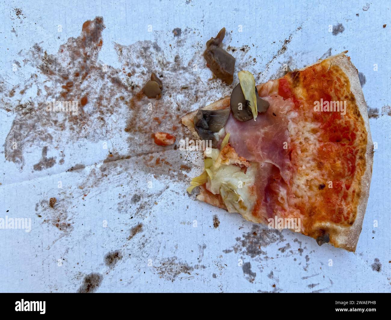 The last bitten slice of pizza on a cardboard box Stock Photo - Alamy