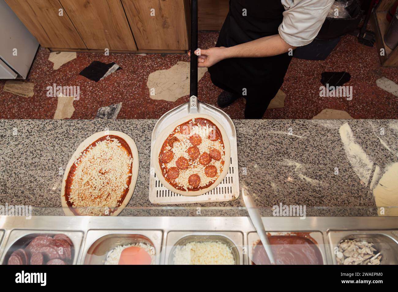 Ready-to-Cook Pepperoni Pizza on Paddle at Pizzeria Stock Photo - Alamy