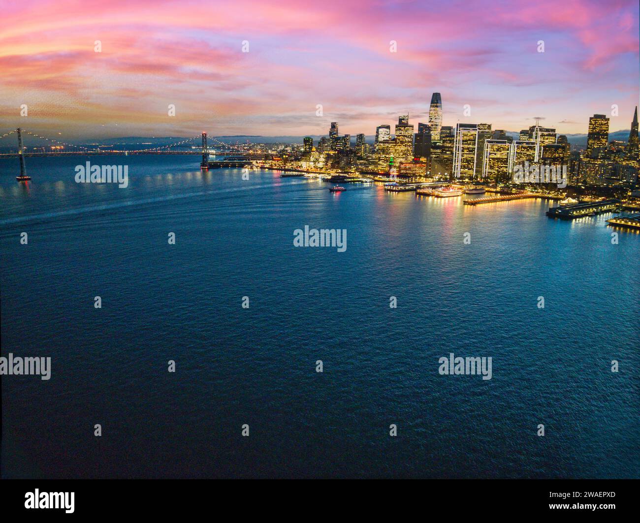 An aerial view of San Francisco city skyline at sunset, illuminated by ...