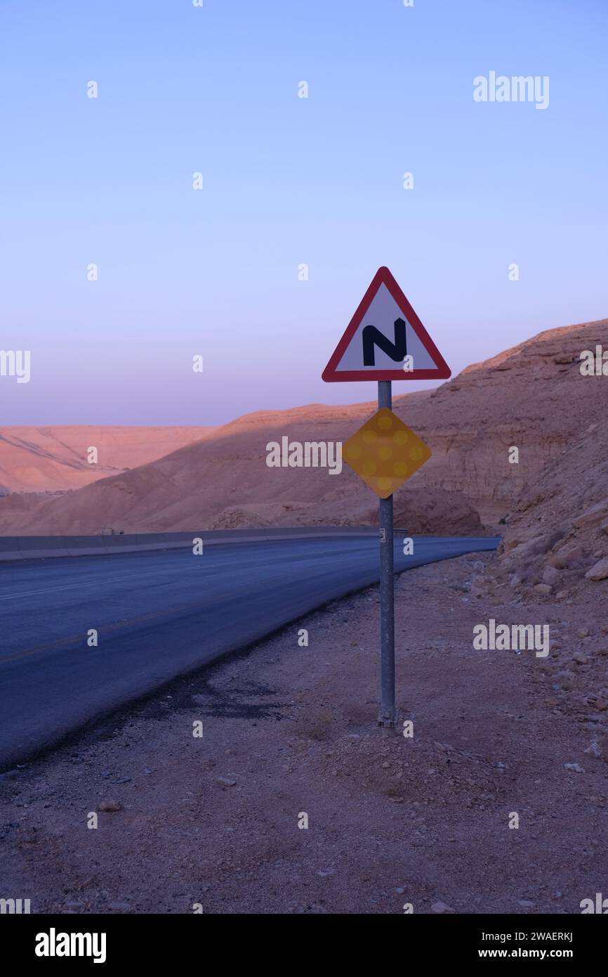 Double bend first to right sign between the mountains Stock Photo - Alamy