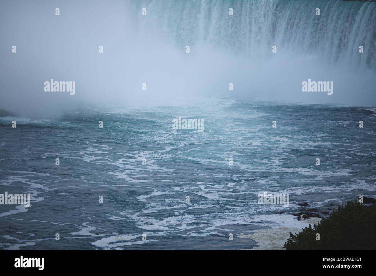 A scenic view of a waterfall cascading into a pool of blue water below ...