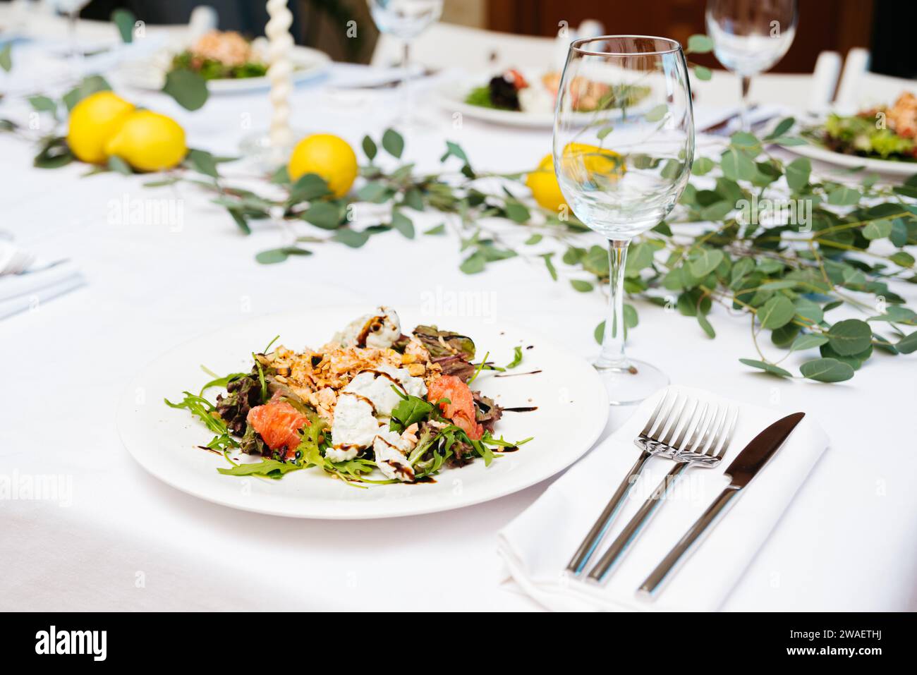 A bright, fresh salad beautifully served on a white plate at an elegant ...
