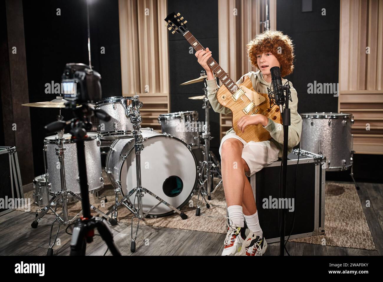good looking red haired teenager playing his guitar and singing song ...