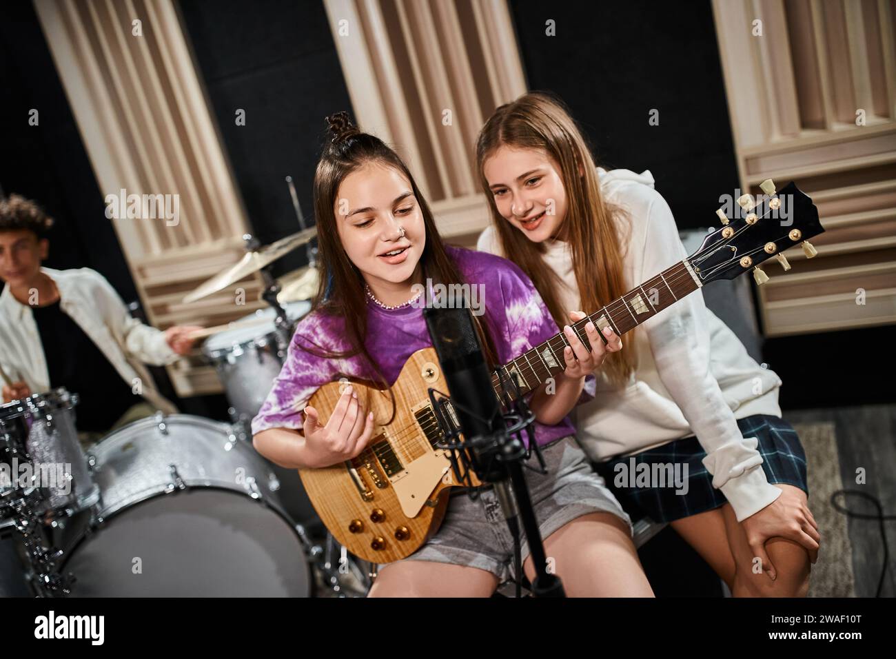 focus on cheerful talented girls playing guitar and singing with their ...