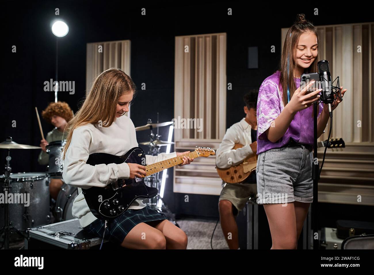 jolly adorable teenagers in casual cozy outfits playing guitars and ...