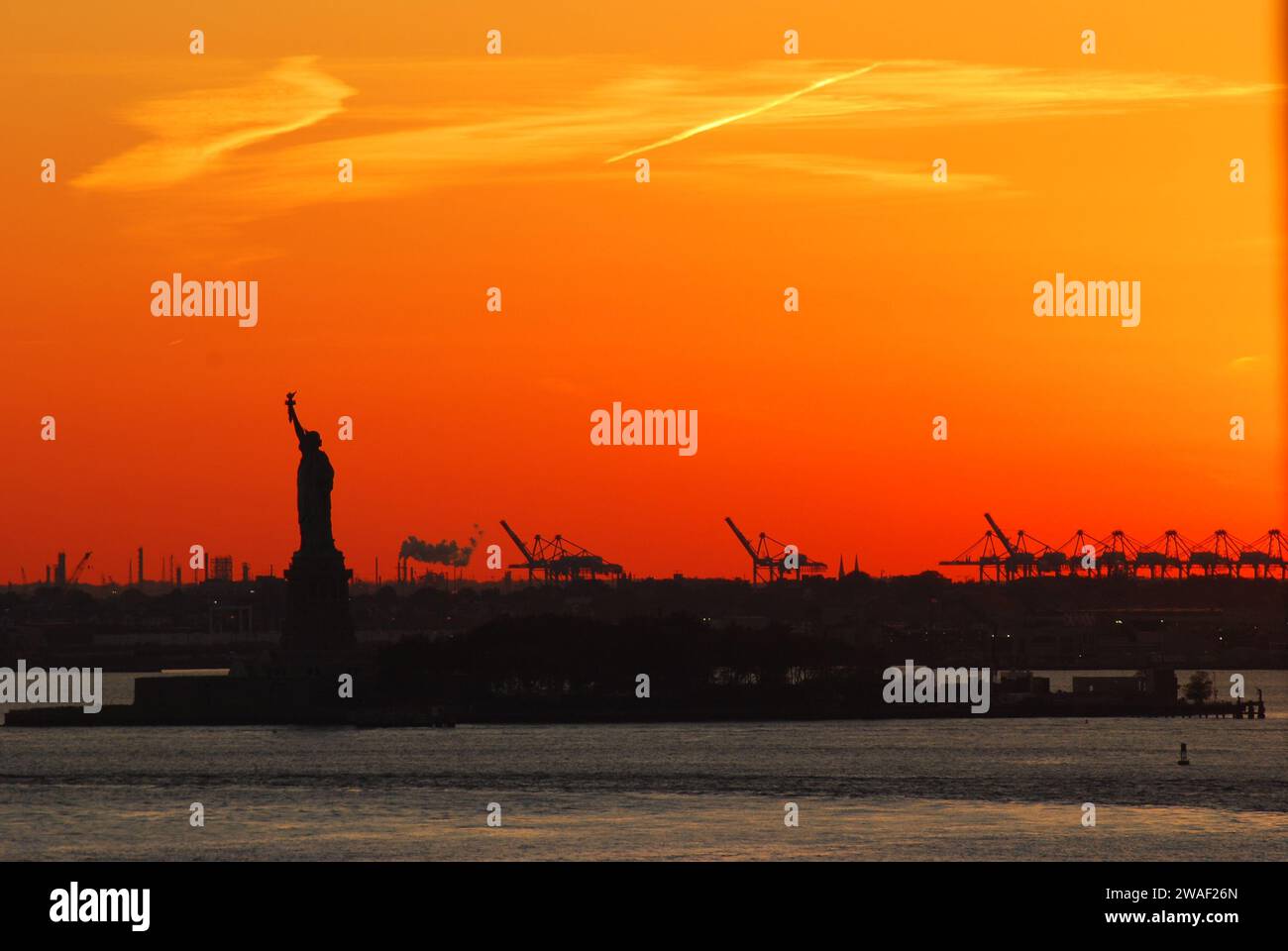 Silhouette of Statue of Liberty and Liberty Island in New York against ...