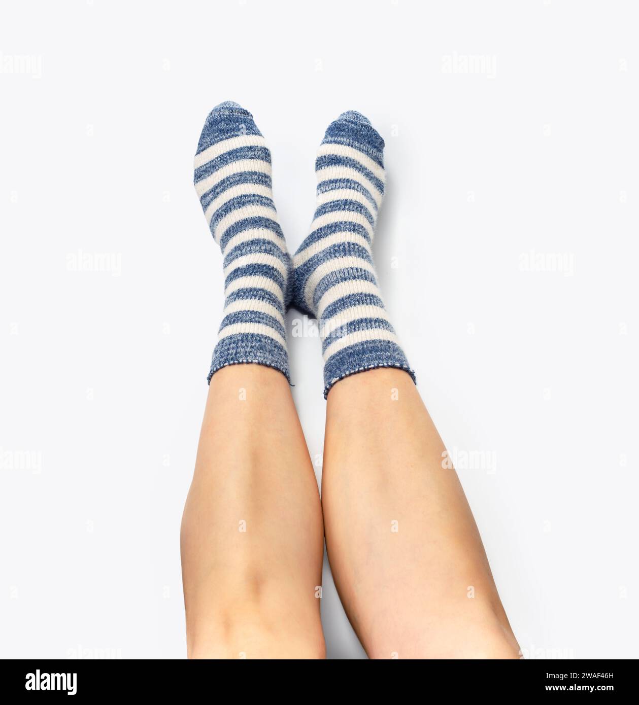 Legs in socks of two colors alternate, blue and white. White background ...