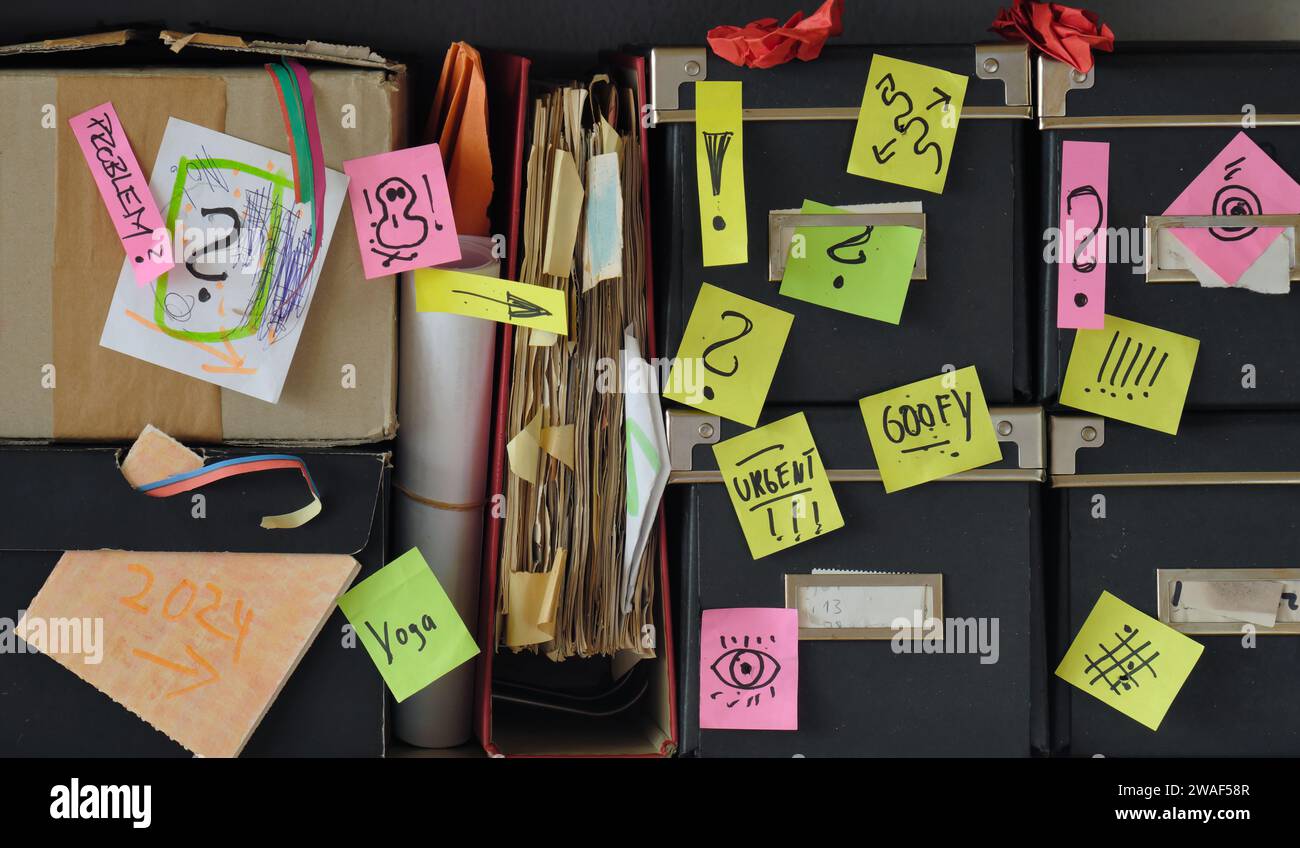 messy shelf with file folder,sticky notes,old papers and storage boxes ...