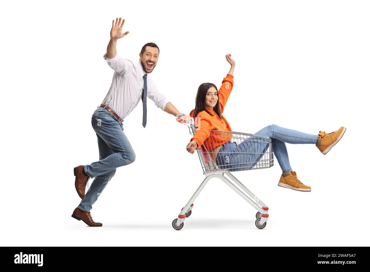 Man running and pushing a happy young female inside a shopping cart ...