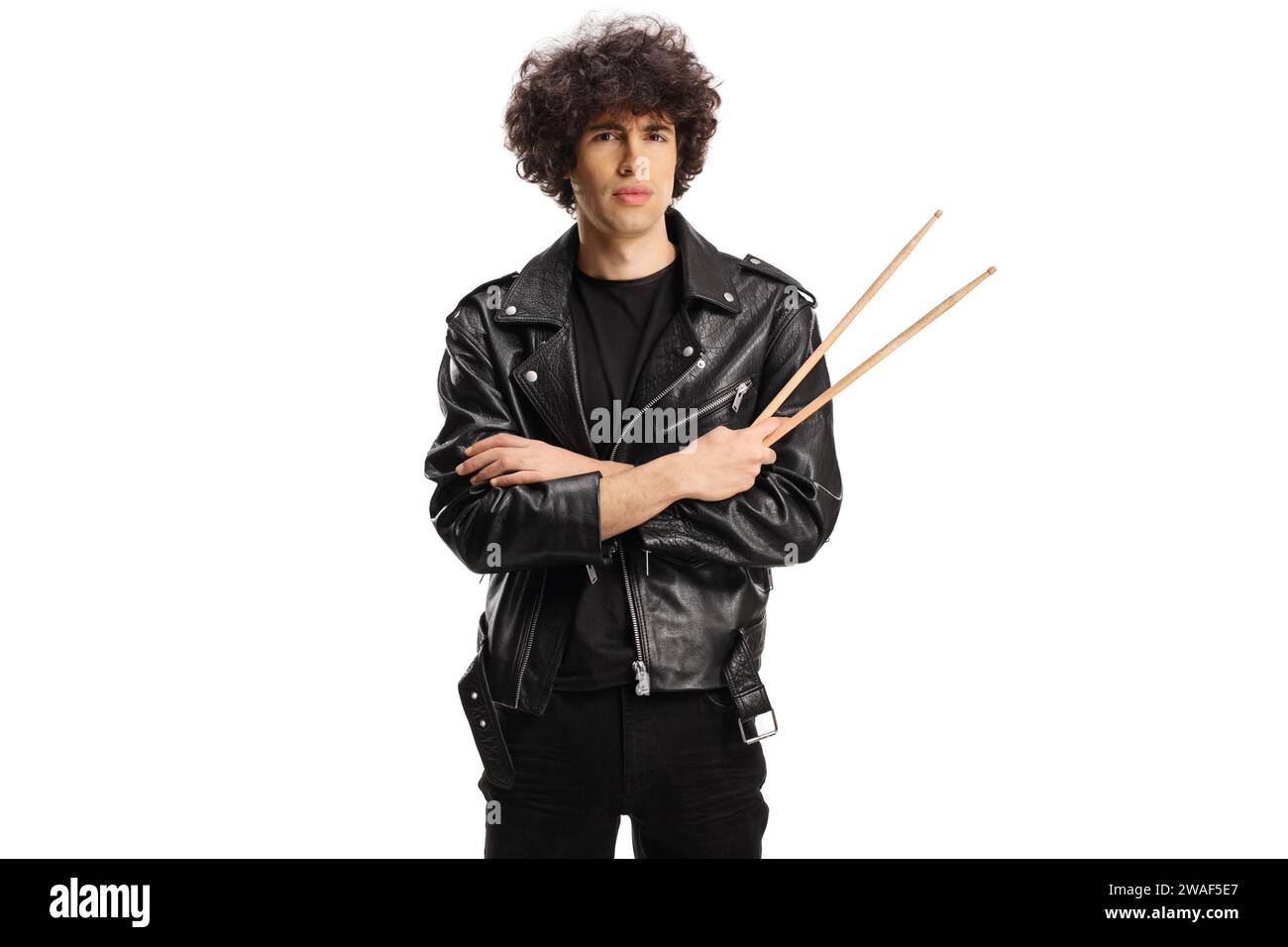Young drummer standing and holding a pair of drumsticks isolated on ...