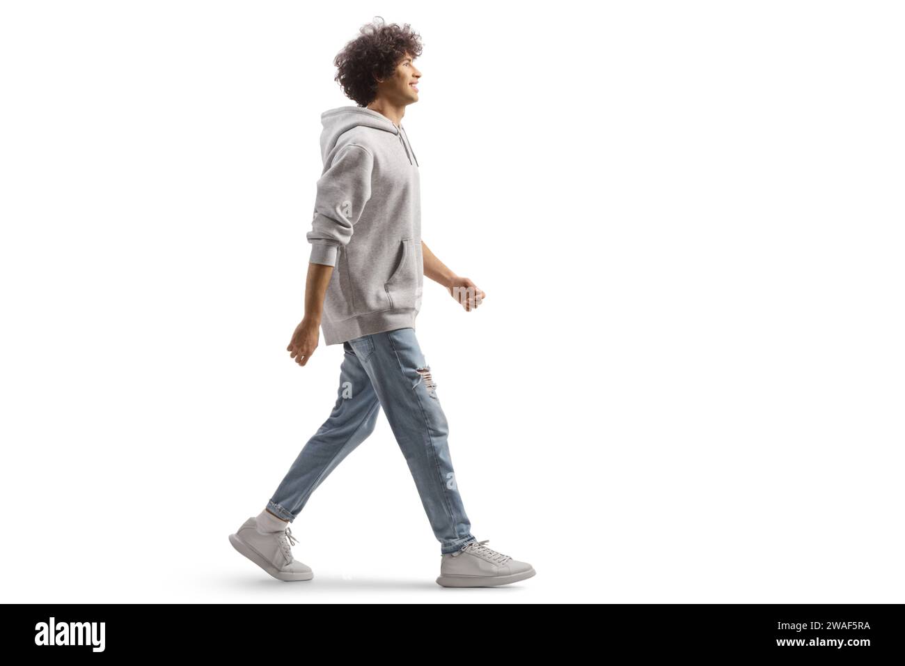 Full length portrait of a tall guy with curly hair walking isolated on ...