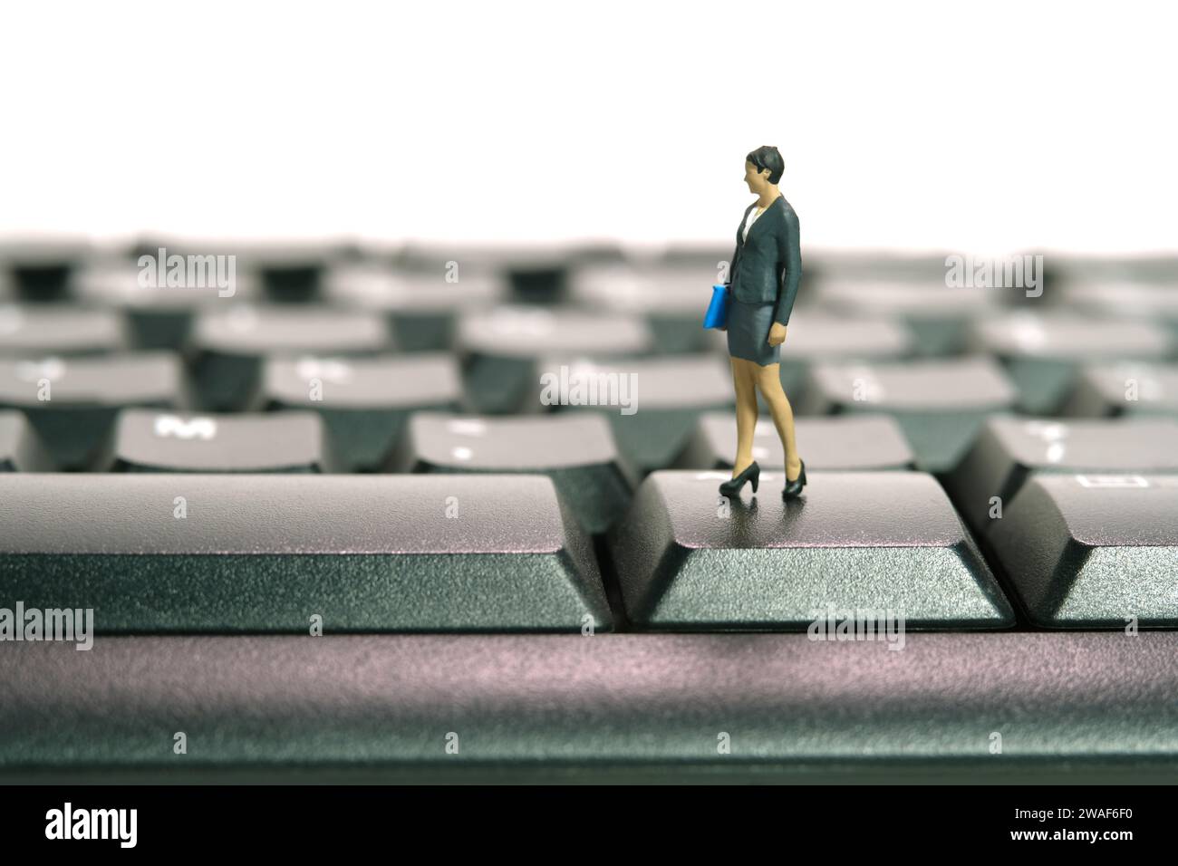 Miniature people toy figure photography. Typing job concept. A ...