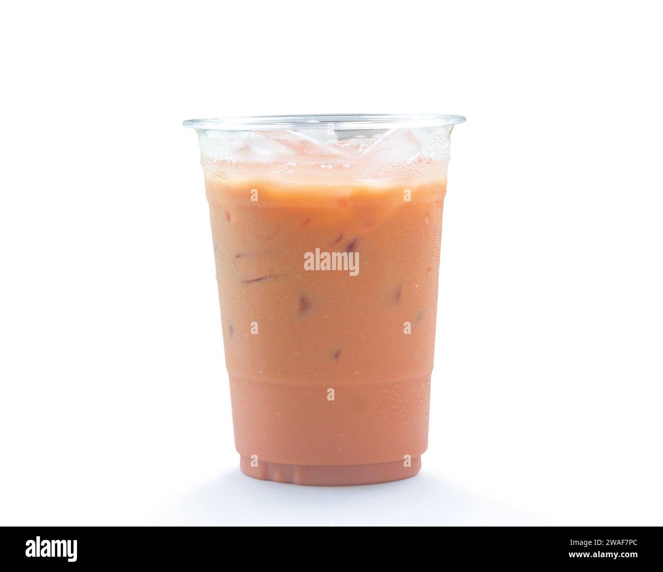Orange Thai iced condensed milk tea in transparent plastic glass is ...