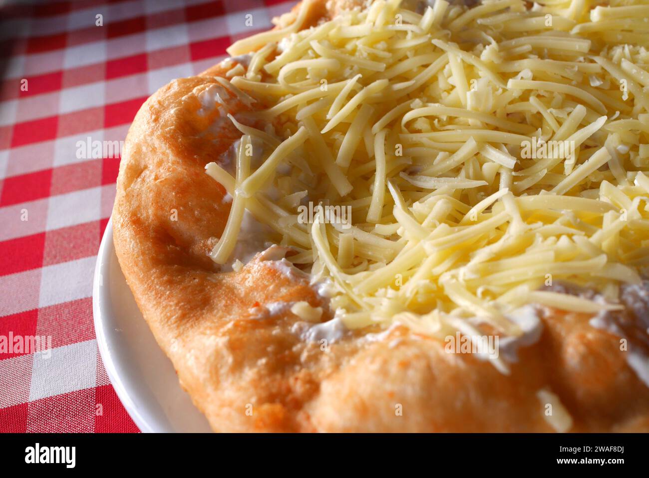 Traditional Hungarian lángos served with sour cream (tejfol) and ...