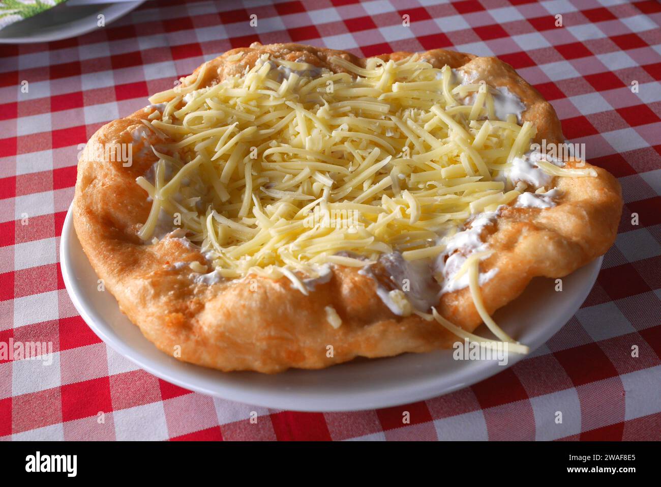 Traditional Hungarian lángos served with sour cream (tejfol) and ...
