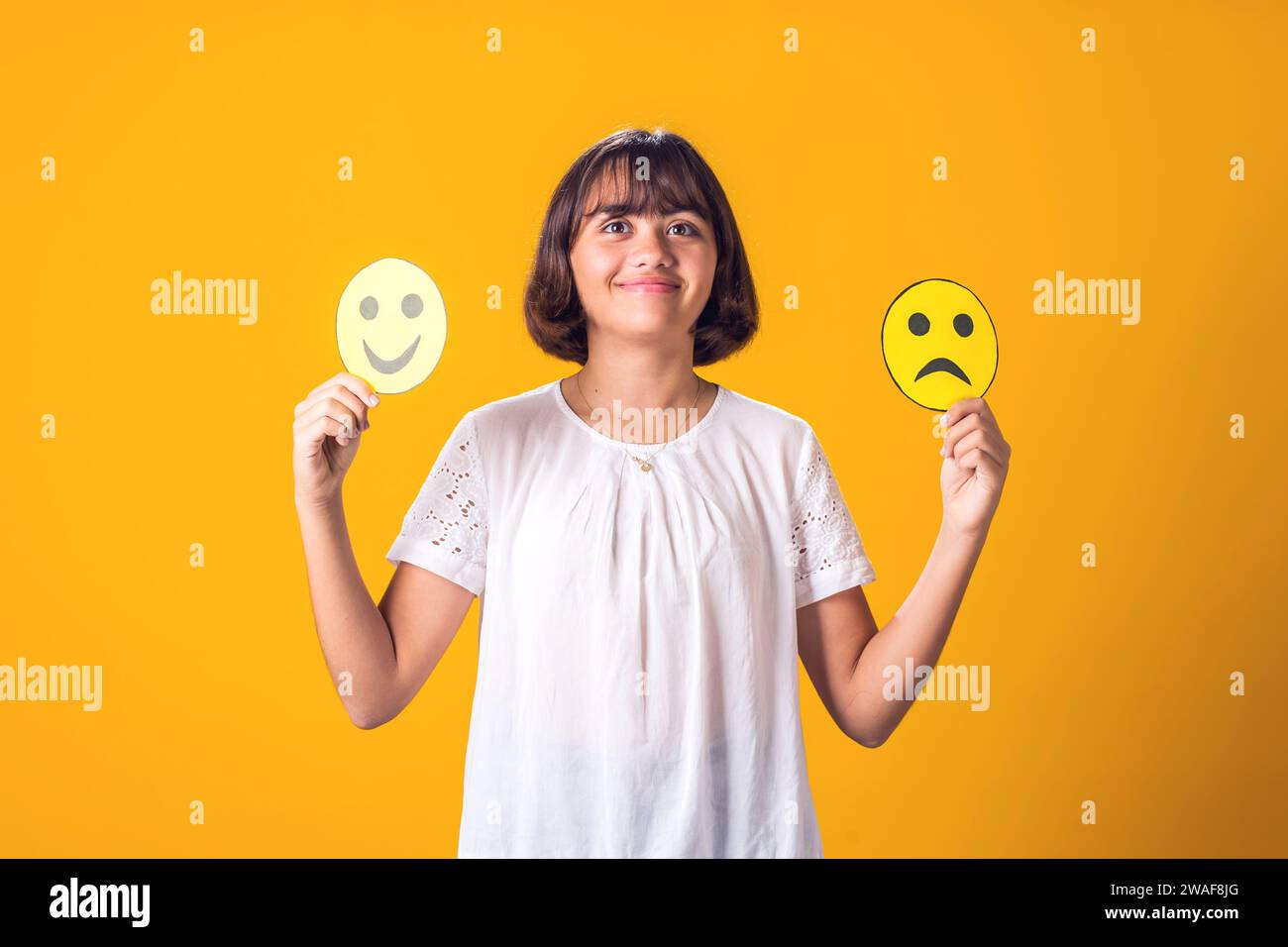 Girl holds sad and happy emoticons in hands. Mental health, psychology ...