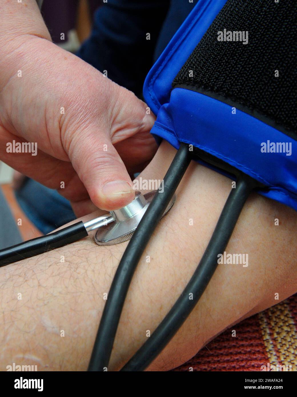 Paramedic's hand taking blood pressure and heart rates by tonometer ...