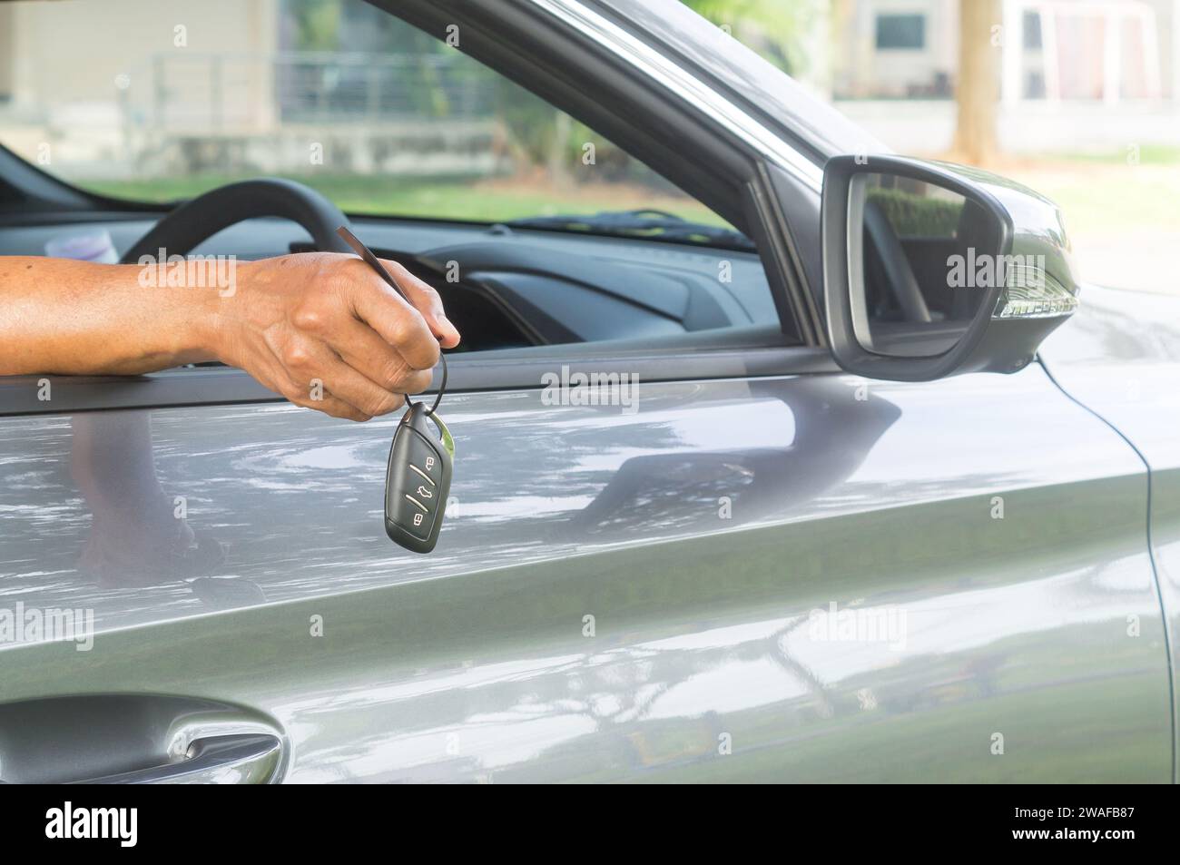 Seller is handing over a key remote control to buyer from inside the ...