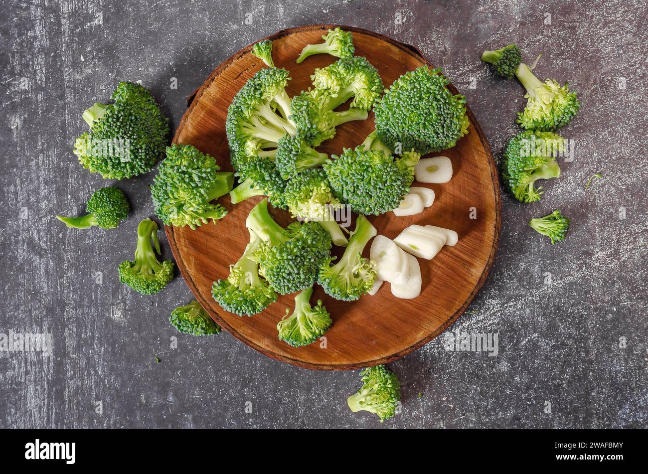 Inflorescences of green broccoli and garlic - still life image. Wooden ...