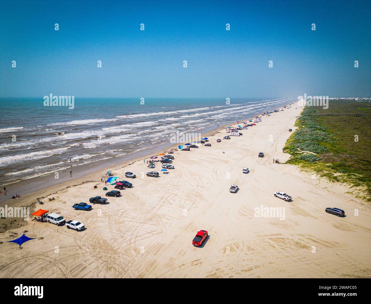 An aerial view of cars parked along the beach on the Texas coast. Port ...