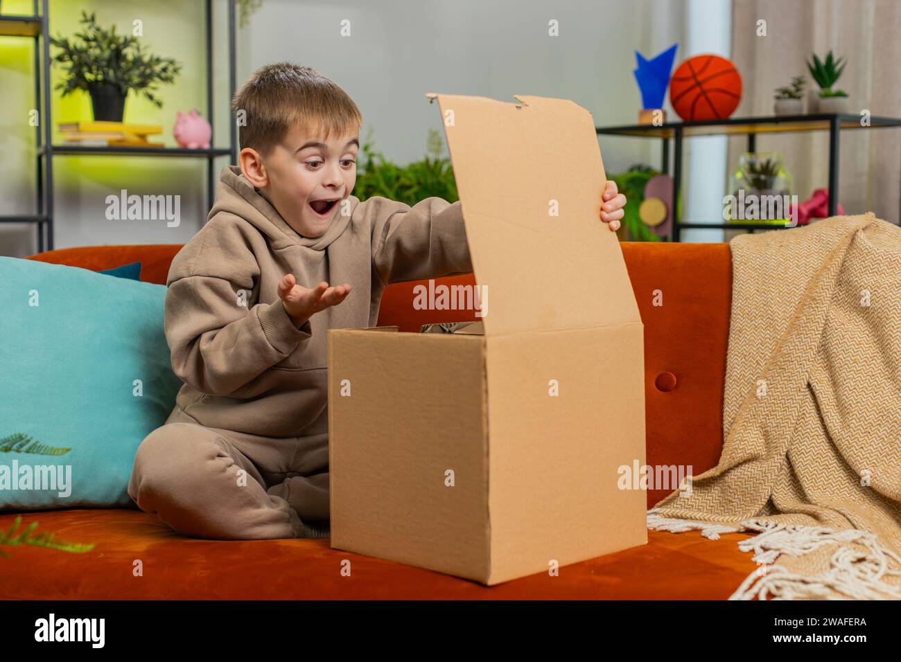Happy excited shocked child boy unpacking delivery parcel. Smiling ...