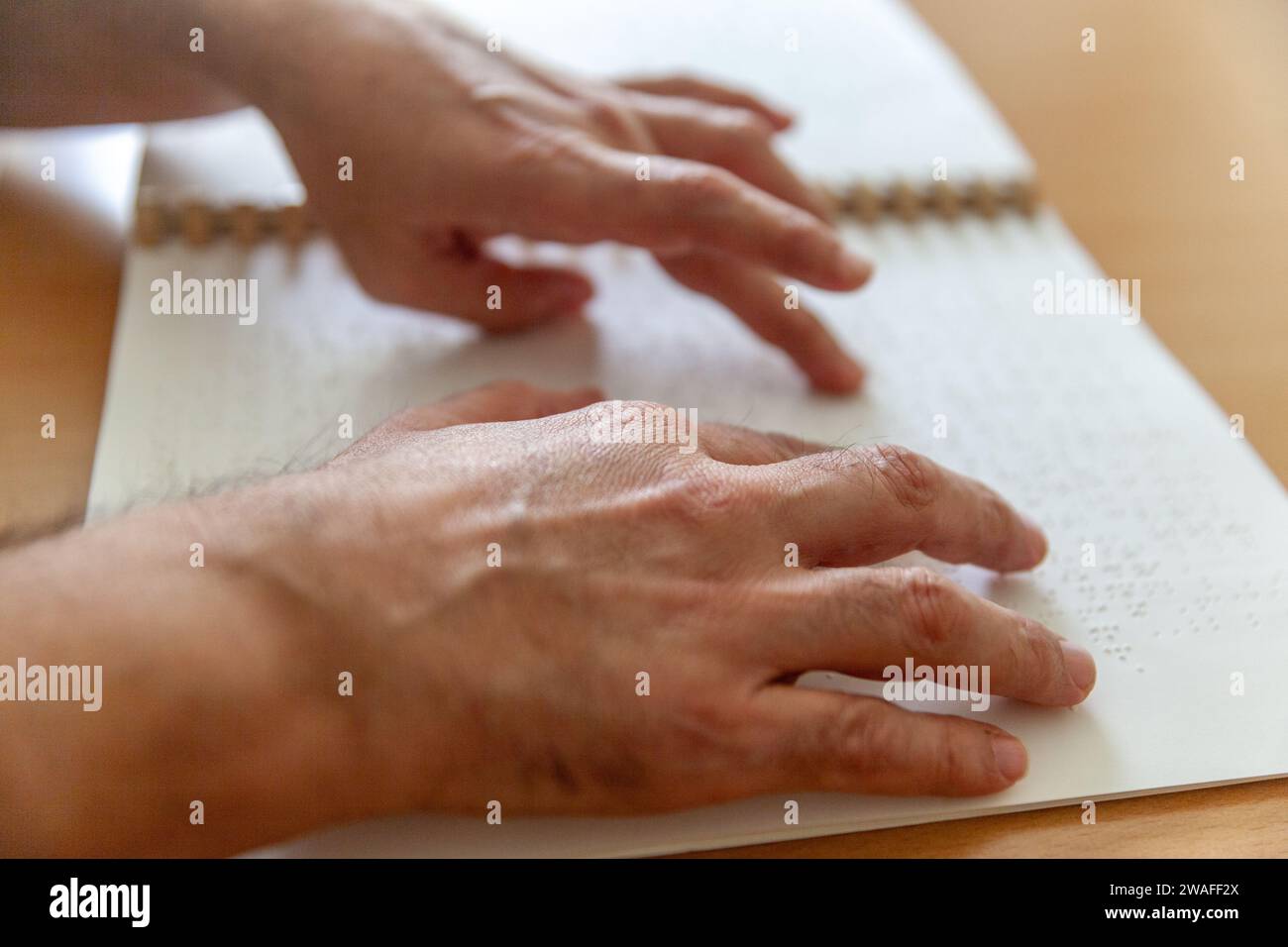 Blind or visually impaired person reading a book printed with braille ...