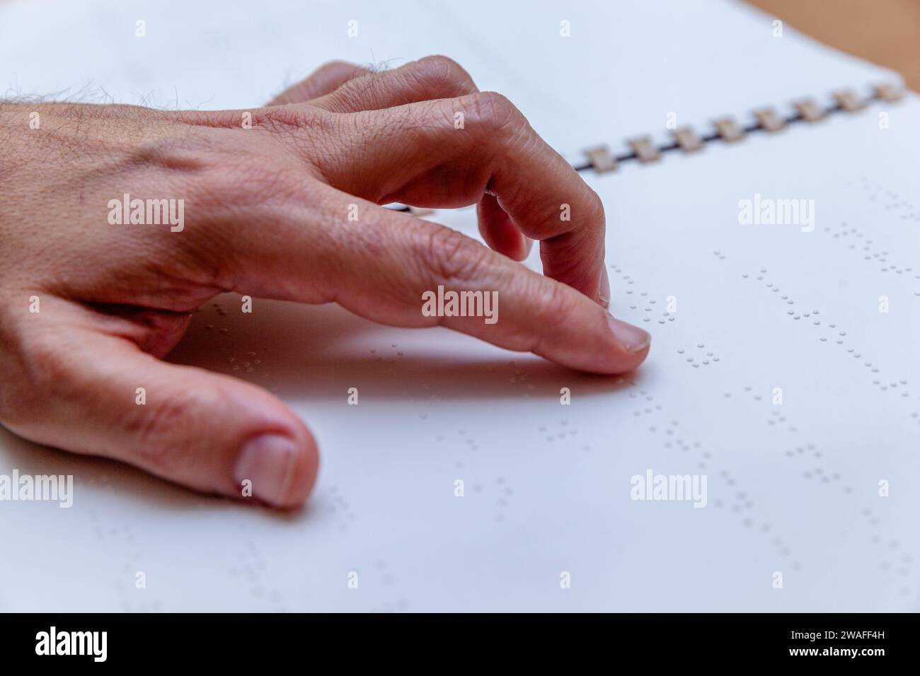 Blind or visually impaired person reading a book printed with braille ...