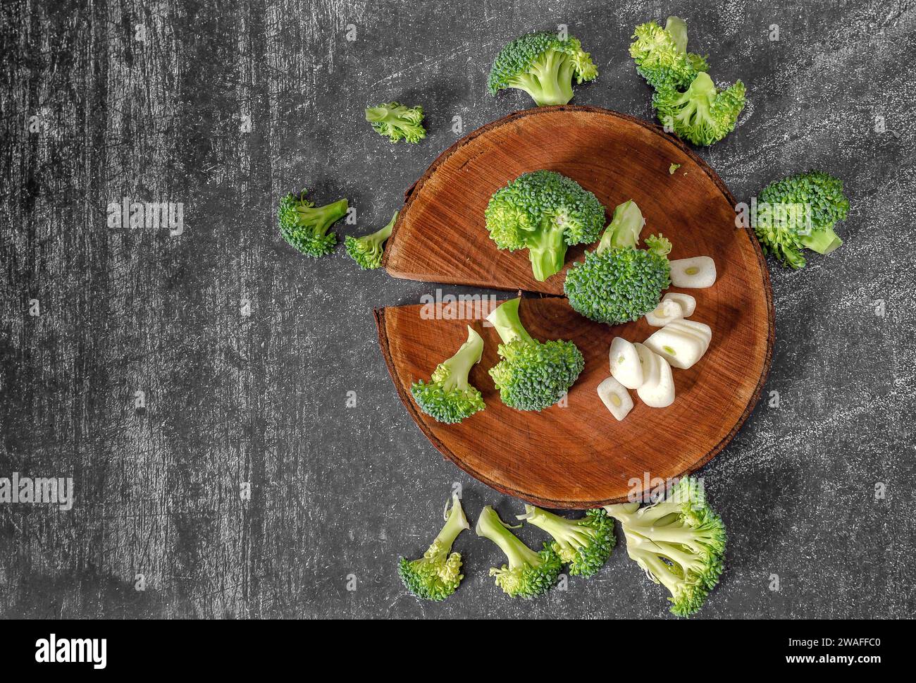 Inflorescences of green broccoli and garlic - still life image. Wooden ...