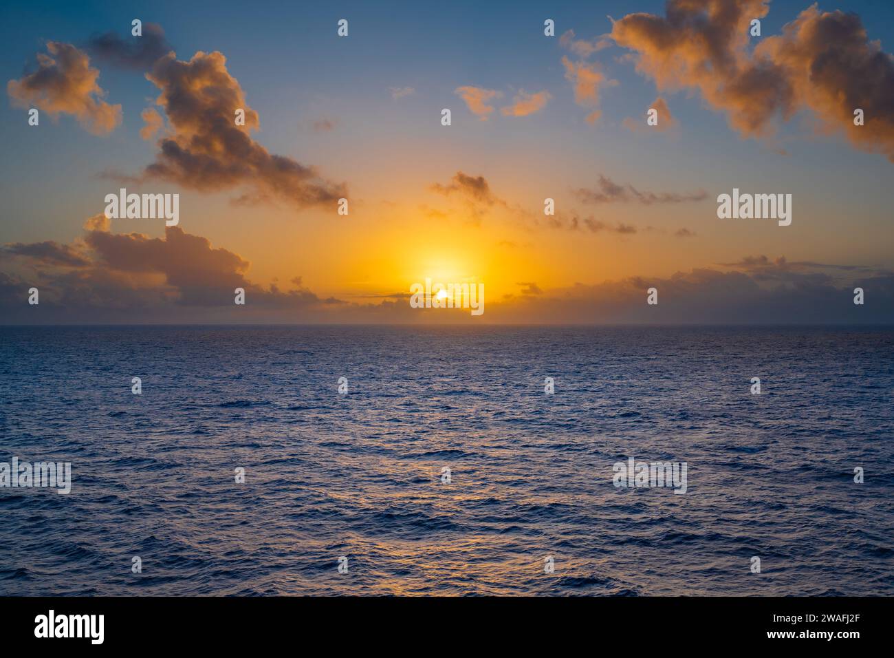 A beautiful sunset is captured over the crystal blue waters of the ...