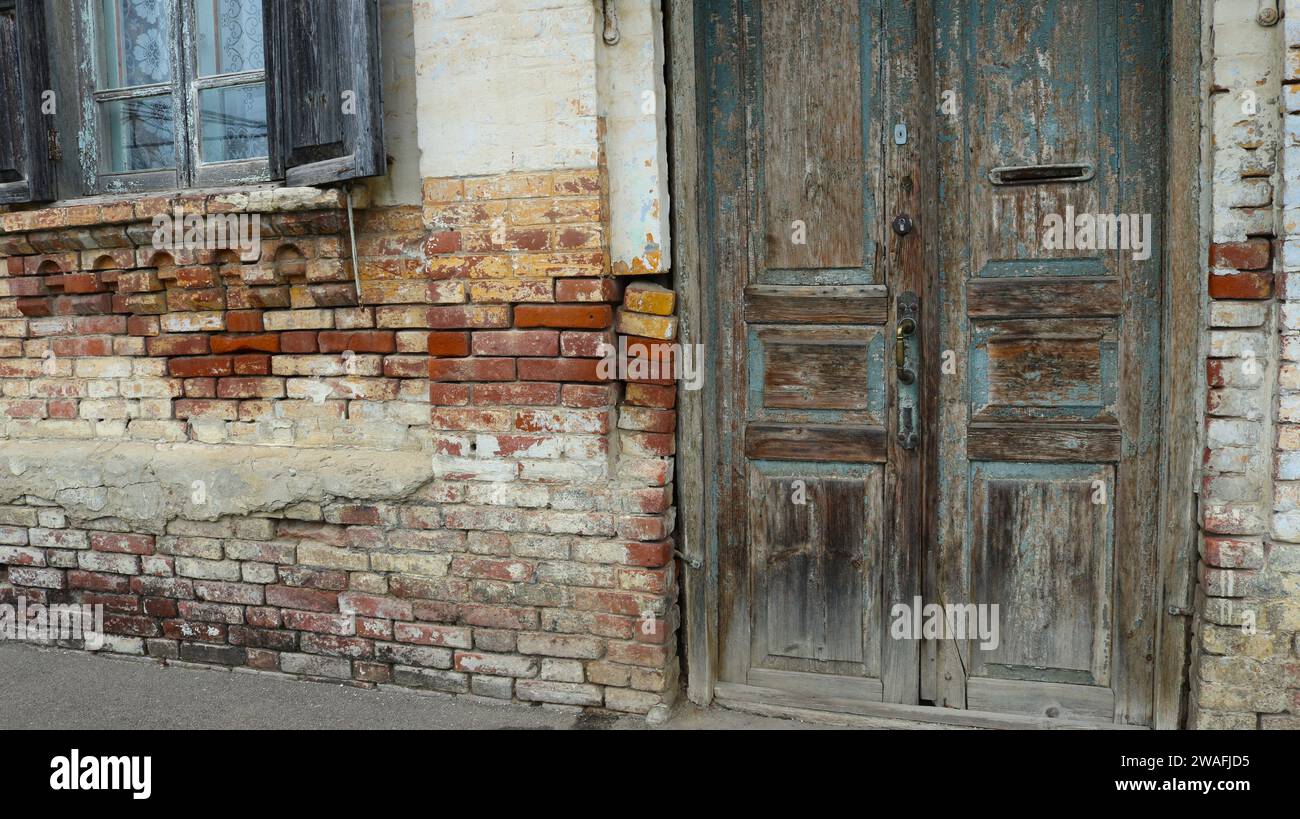fragment of the external wall of an ancient house with a shabby wooden ...