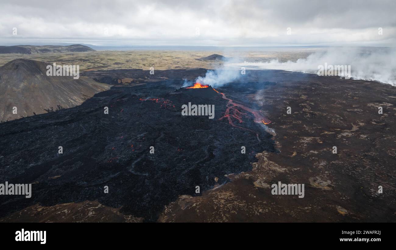 Dramatic view of an erupted volcano, red magma boiling in a crater ...