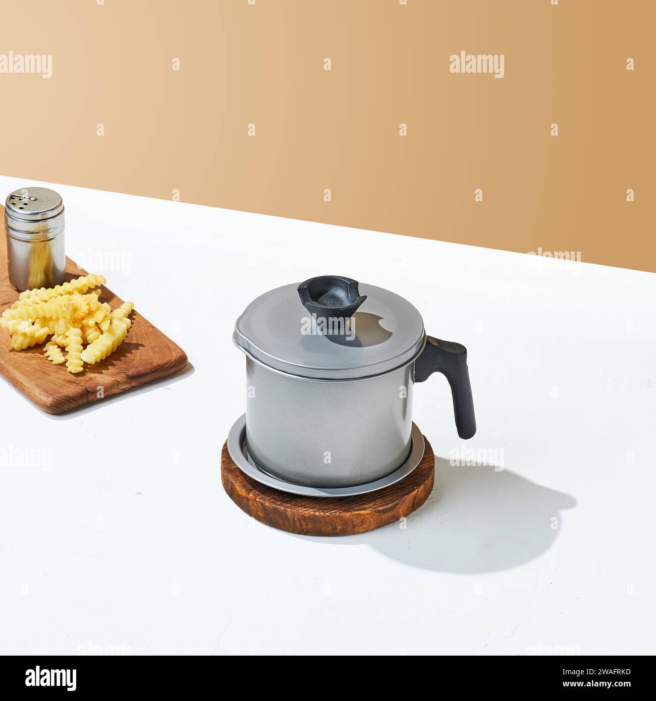 A stainless steel oil tray, with fried fries and sausage on top and on ...