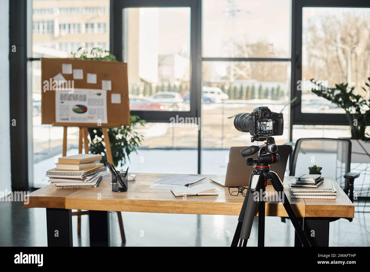 digital camera near work desk with laptop and flip chart with graphs in ...