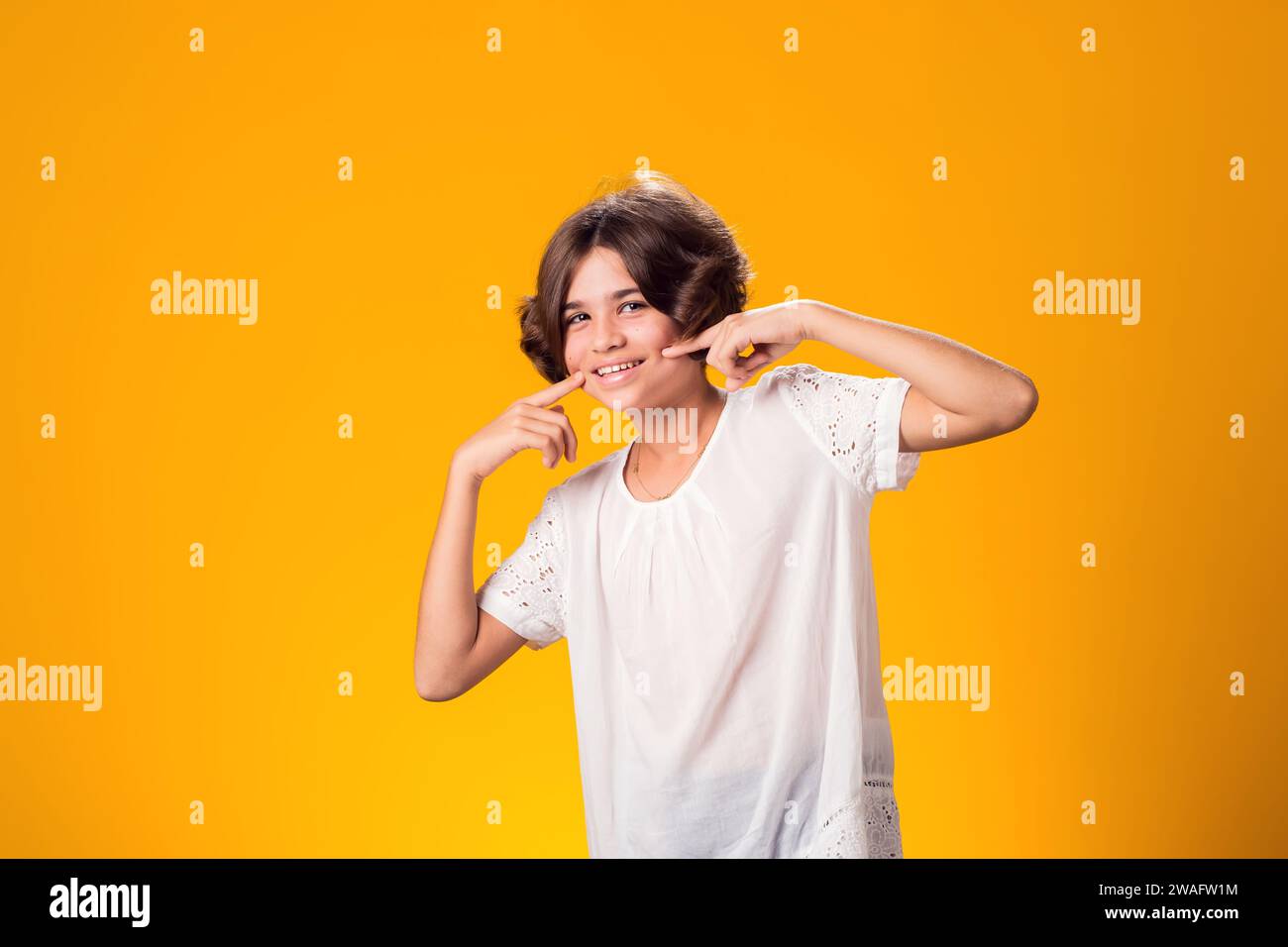 Smiling kid girl over yellow background. Emotion concept Stock Photo ...