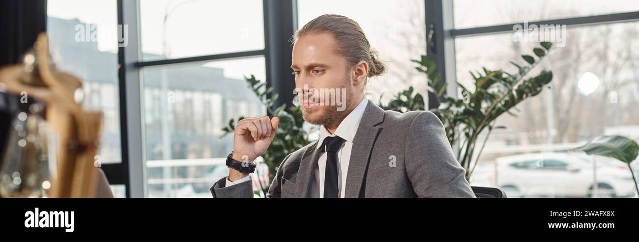 serious task-oriented businessman in grey suit sitting and thinking at ...