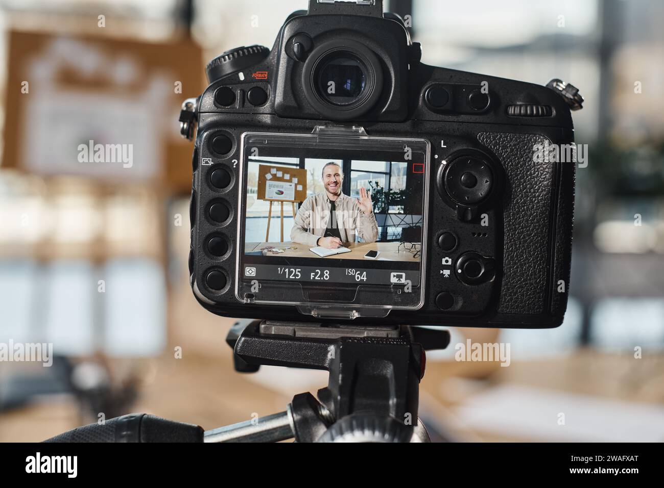 close up view of digital camera near cheerful businessman recording ...