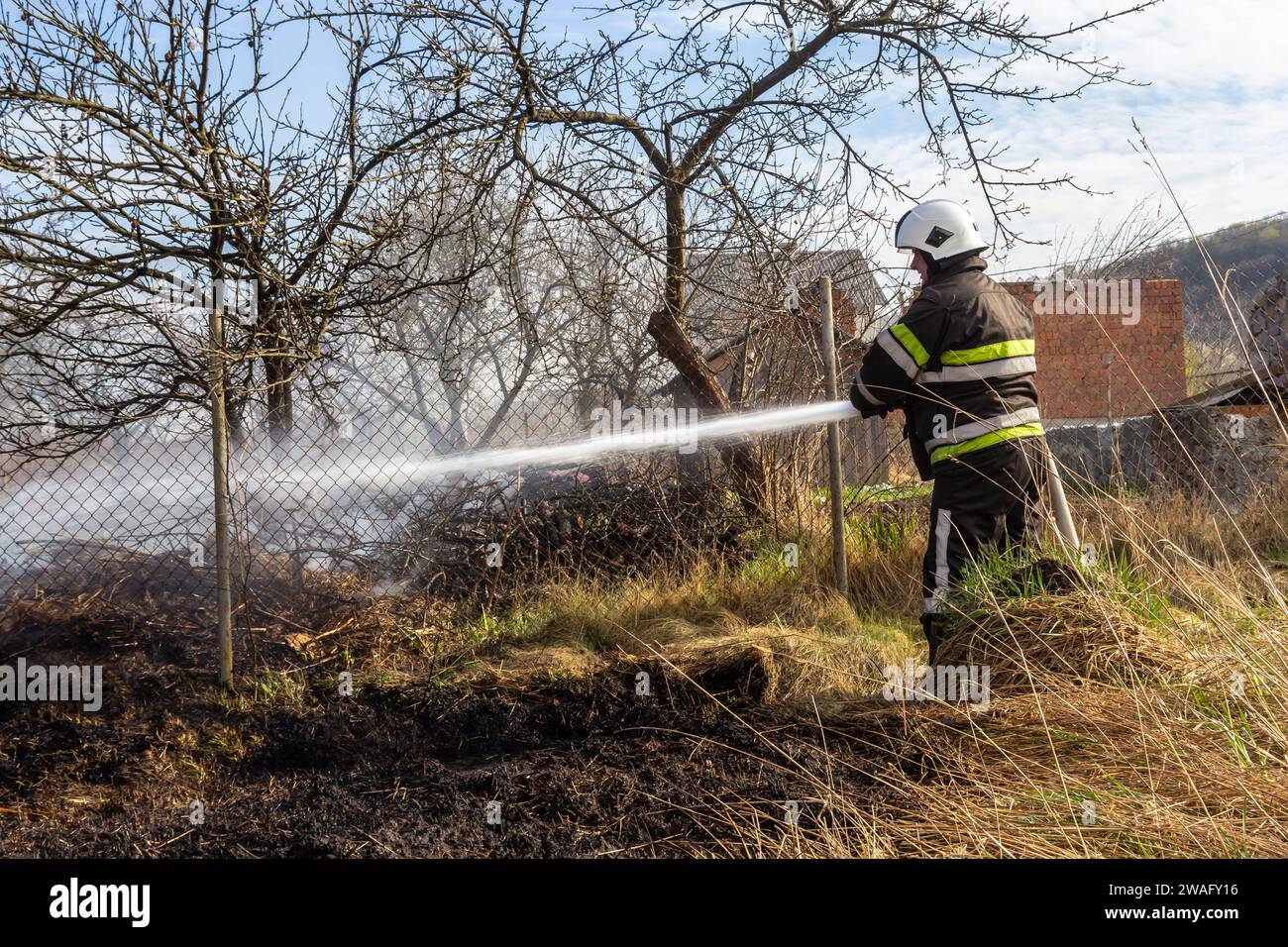 spring fire, burning dry grass near buildings in the countryside ...