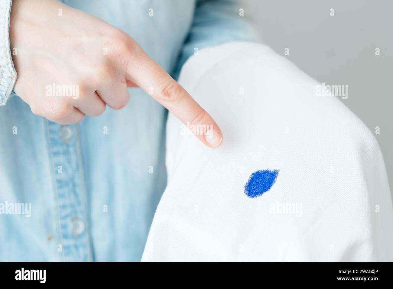 Dirty ink stain on a white clothes. Unrecognizable woman holding ...